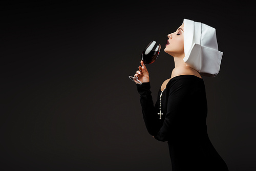 유토이미지 | attractive passionate nun drinking red wine from glass isolated ...