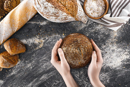 유토이미지 | cropped shot of human hands holding loaf of healthy homemade bread
