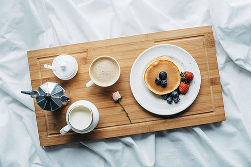 top view of breakfast in bed with freshly baked pancakes and coffee on ...