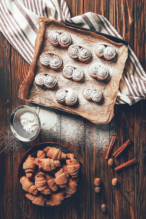 elevated view of delicious baked cookies on plate and tray in bakery ...