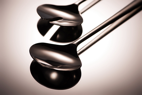 유토이미지 | close-up view of shiny stainless steel ladles reflected on grey