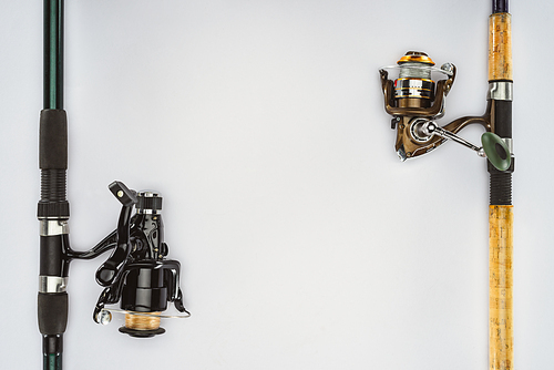 top view of two arranged fishing rods isolated on white, minimalistic ...