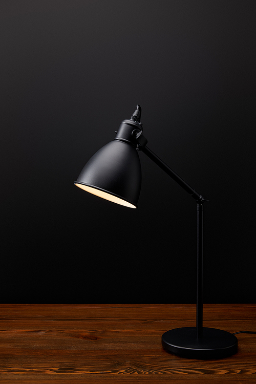 유토이미지 | close up view of black lamp on wooden tabletop on black background