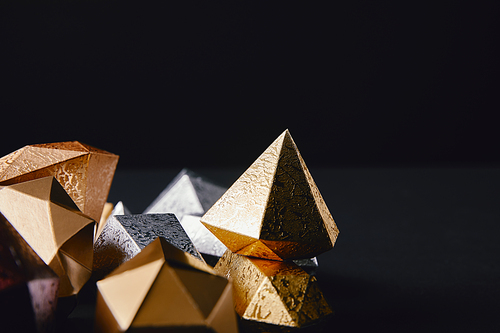 close-up view of shiny faceted golden and silver pieces on black ...