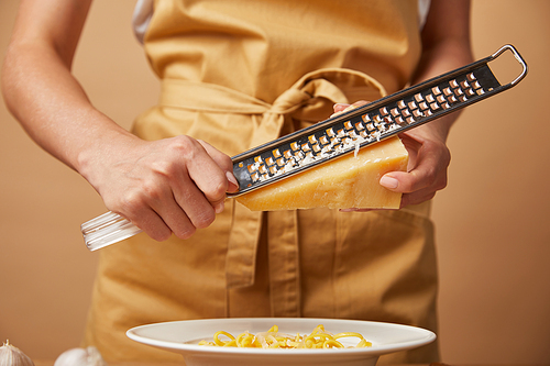 유토이미지 | cropped shot of woman grating cheese onto spaghetti