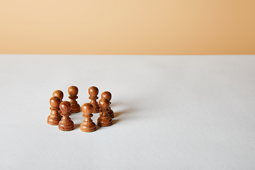 유토이미지 | wooden pawn pieces on white table and beige background