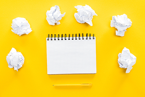 유토이미지 | blank spiral notebook and crumbled paper balls on yellow background