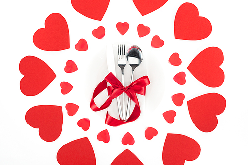 elevated view of cutlery wrapped by red festive ribbon surrounded by ...
