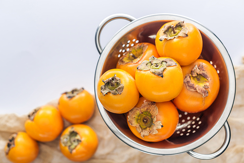 유토이미지 | selective focus of ripe whole orange persimmons in colander