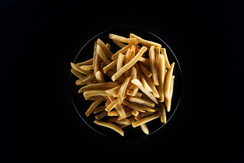 유토이미지 | top view of tasty french fries on plate isolated on black