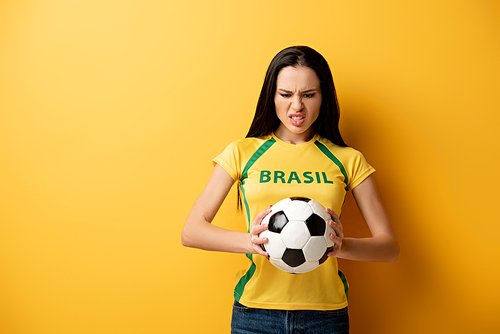 유토이미지 | aggressive female football fan holding ball on yellow