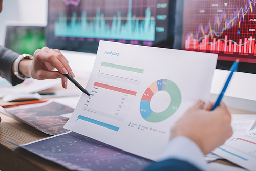 유토이미지 | Cropped view of computer systems analysts working with charts at table