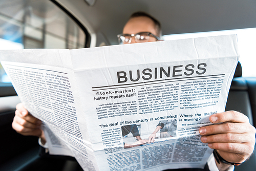 유토이미지 | selective focus of man reading business newspaper in car
