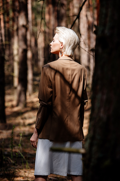 유토이미지 | pensive blonde woman in brown jacket standing in forest