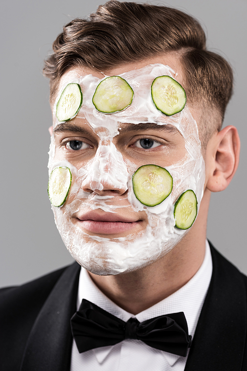 young man in formal wear with cucumber facial mask isolated on grey ...