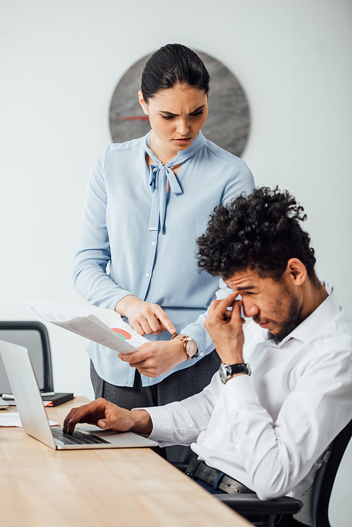 유토이미지 | Skeptical mexican businesswoman pointing at wristwatch near ...