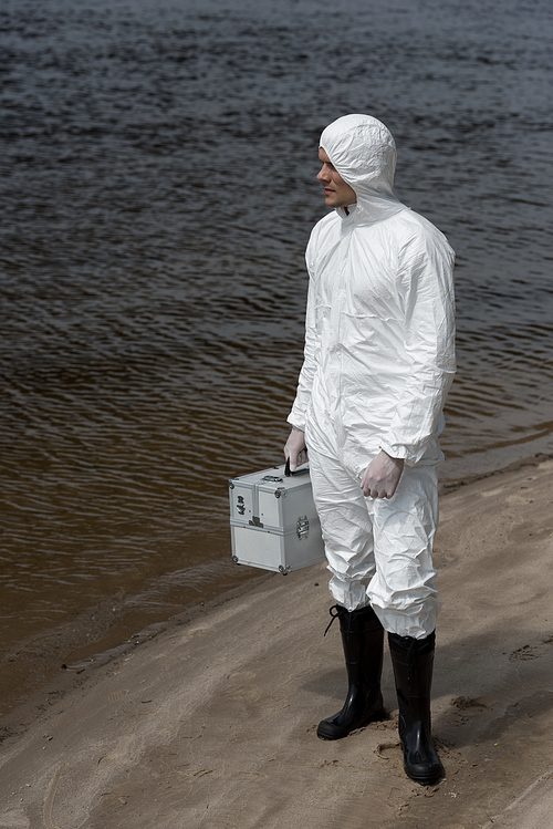 full length view of water inspector in protective suit holding ...