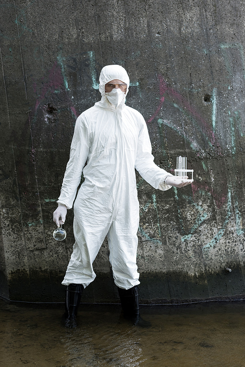 full length view of water inspector in protective costume and ...