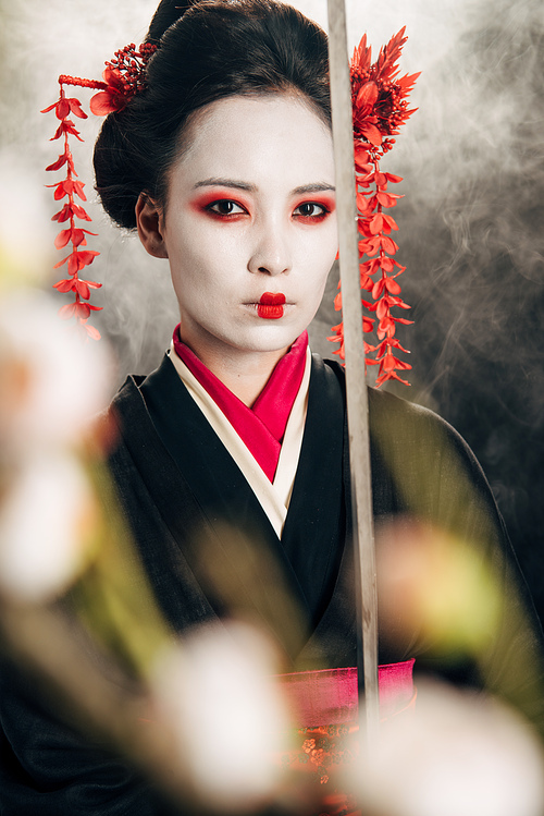 유토이미지 | selective focus of confident geisha in black kimono holding ...