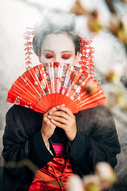 유토이미지 | selective focus of geisha in black kimono with flowers in hair ...
