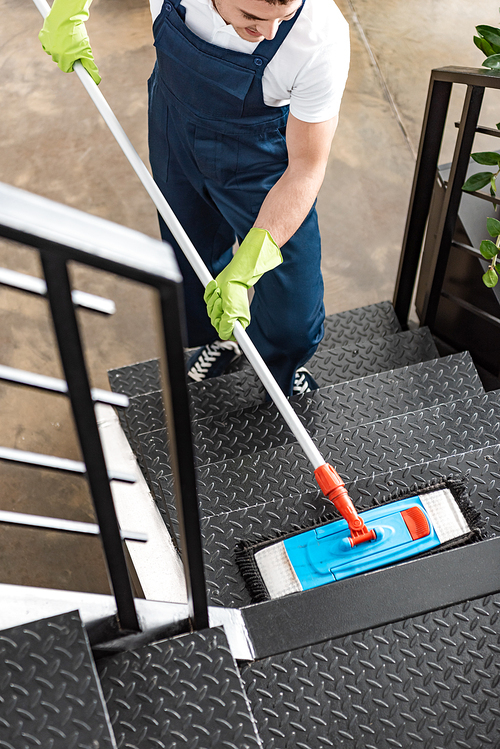 유토이미지 | high angle view of young cleaner washing stairs with mop