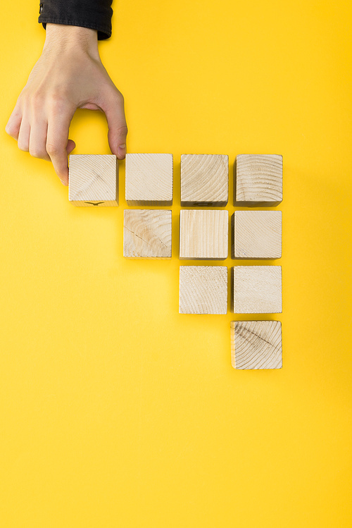 top view of man touching wooden cube isolated on yellow | 유토이미지 | 상세페이지 ...