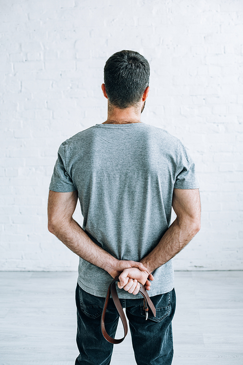 back view of man holding belt at home | 유토이미지 | 상세페이지 | 베이직샵 | 사진 ...