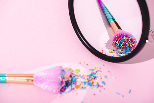 makeup brush covered in colorful sprinkles with reflection in mirror on ...