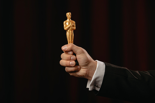 cropped view of man holding oscar award on dark background | 유토이미지 | 상세 ...