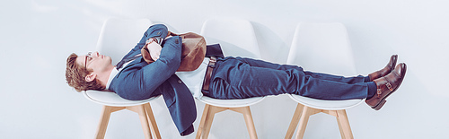 panoramic shot of employee lying on chairs while waiting job interview ...