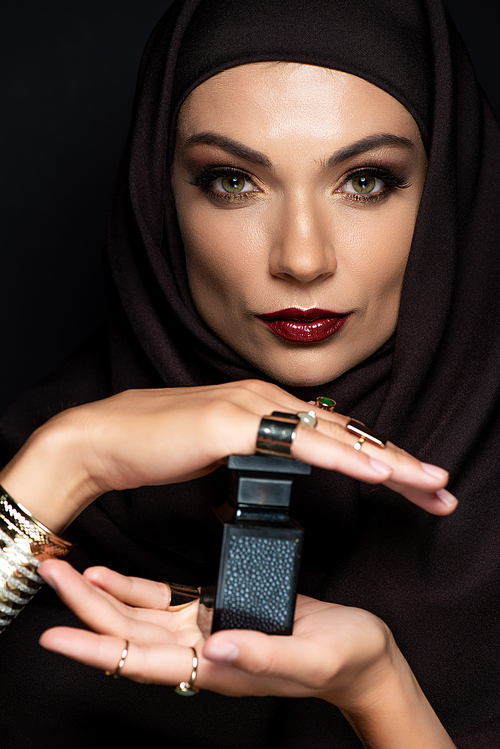 beautiful Muslim woman in hijab with makeup in golden jewelry holding ...
