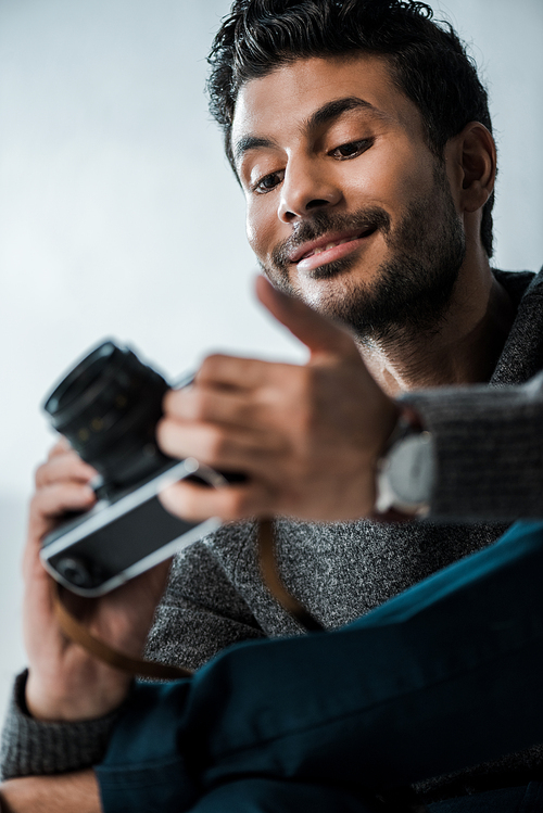 유토이미지 | low angle view of handsome and smiling bi-racial man holding ...