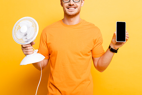 cropped view of smiling man holding smartphone with blank screen and ...