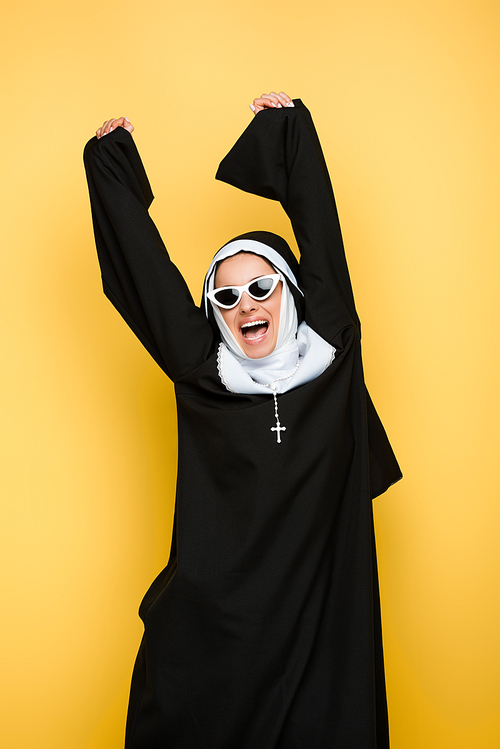attractive excited nun dancing in sunglasses isolated on yellow | 유토이미지 ...