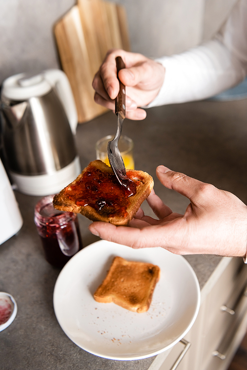 cropped view of man spreading jam on toast for breakfast | 유토이미지 | 상세 ...