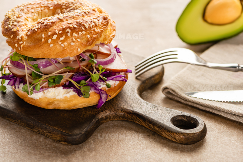 fresh delicious bagel with meat, red onion, cream cheese and sprouts on ...