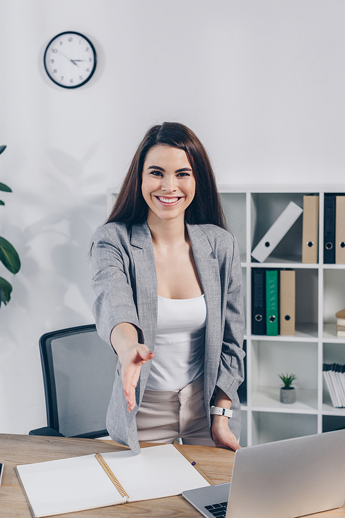 유토이미지 | Recruiter with outstretched hand and smiling at table in office