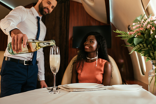 유토이미지 | selective focus of handsome air stewards pouring champagne into ...