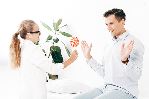 유토이미지 | child in doctor costume giving patient candy in clinic