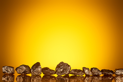 gold shiny stones with reflection on yellow illuminated background | 유토 ...