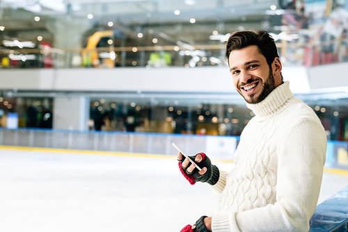 유토이미지 | happy bearded man using smartphone on skating rink