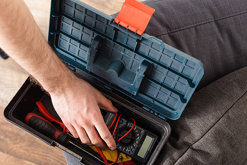 유토이미지 | partial view of handyman taking digital multimeter from toolbox