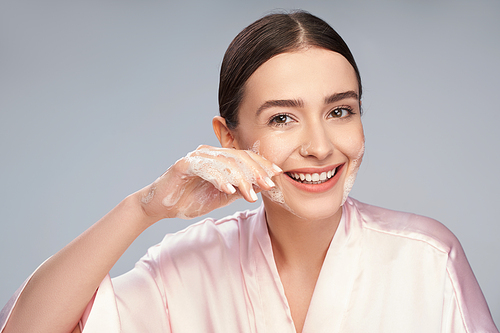 유토이미지 | Close up portrait of charming girl cleaning her cheeks with ...